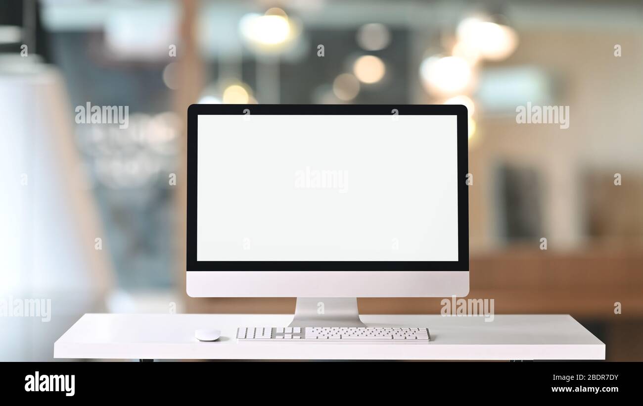 Computer monitor with white blank screen putting on white working desk ...