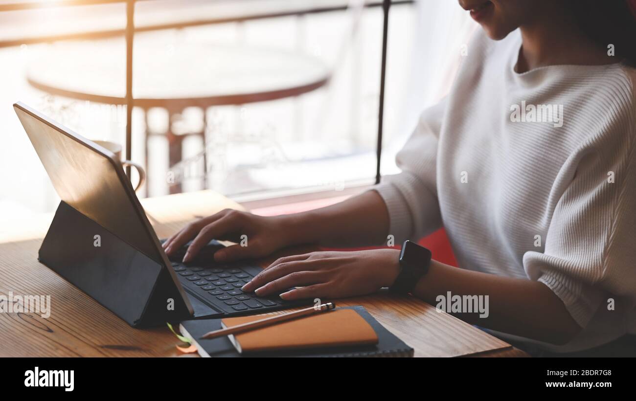 Cropped image of beautiful woman typing on computer tablet with ...