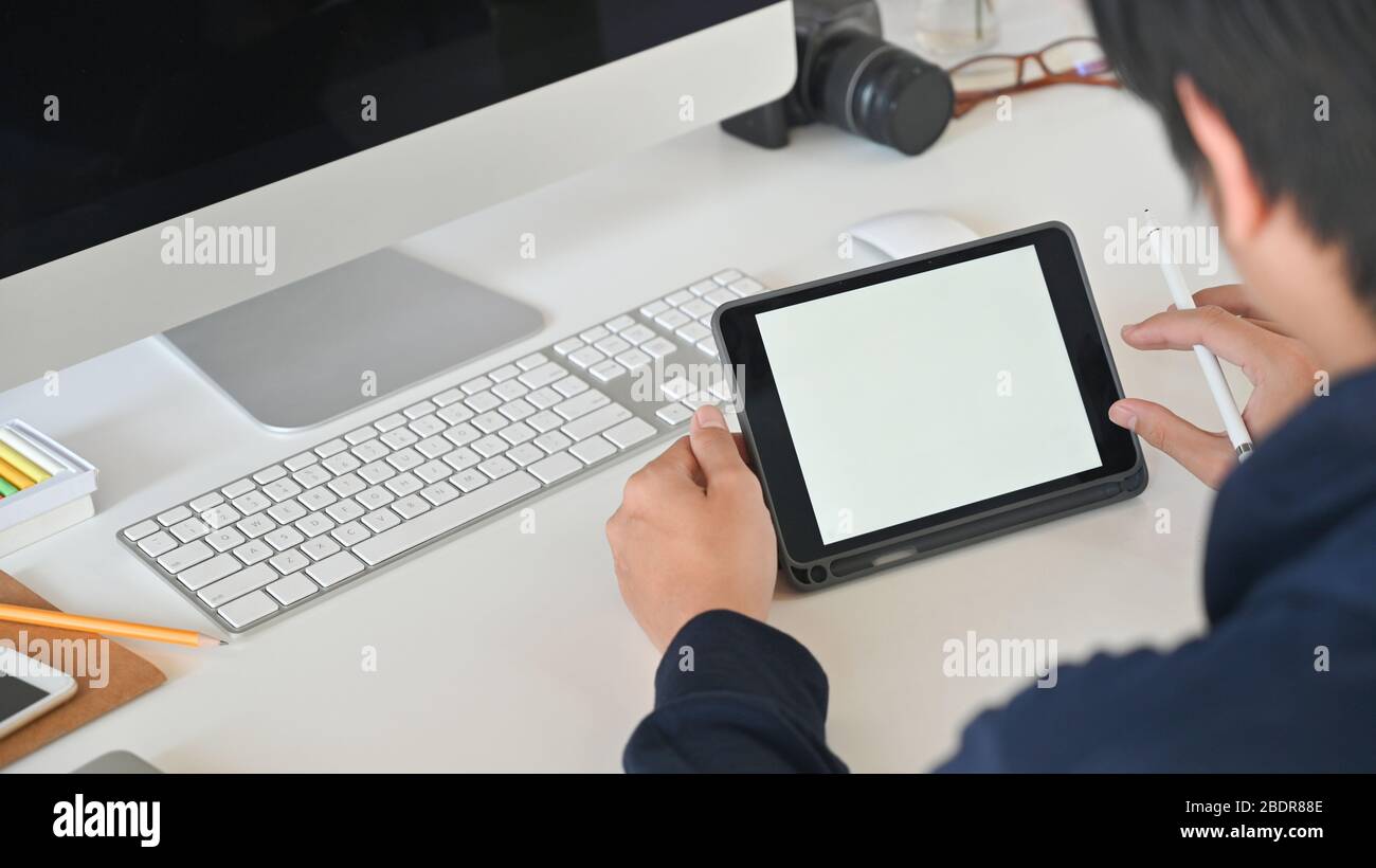 Cropped shot of smart man holding stylus pen in hands while using white ...
