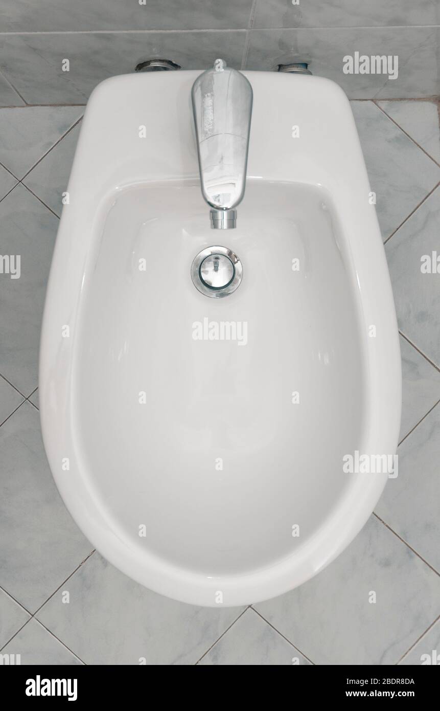 White ceramic bidet in italian bathroom Stock Photo - Alamy