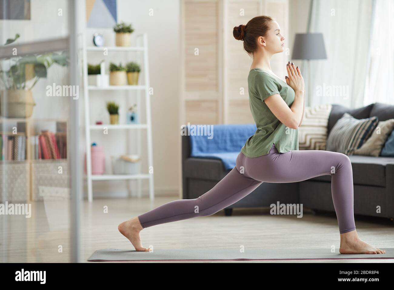 Side view of young healthy woman doing yoga exercises at home Stock ...