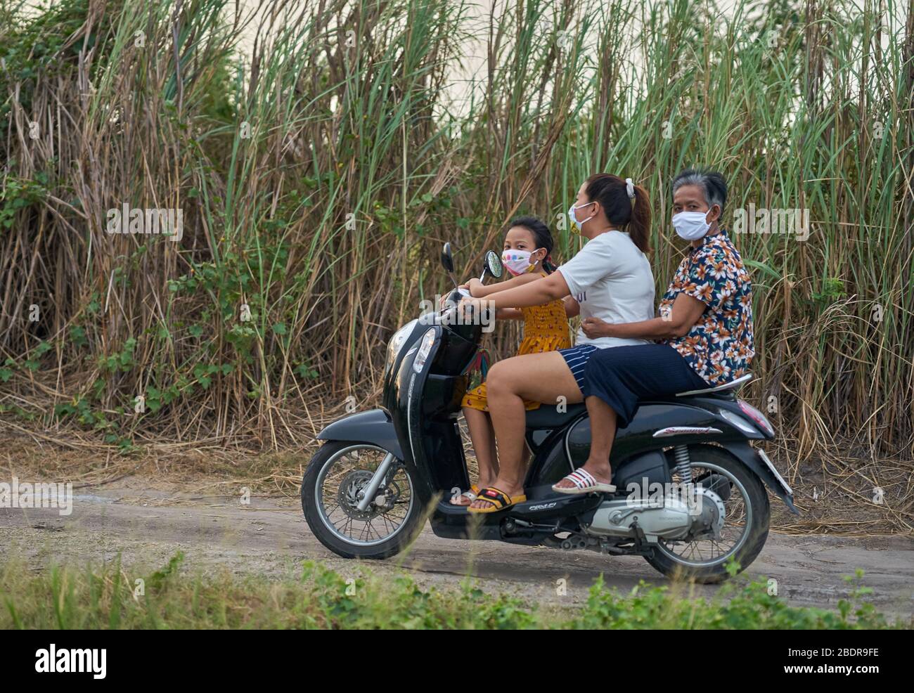 A family on a motorcycle wearing face masks due to Corona virus, in ...