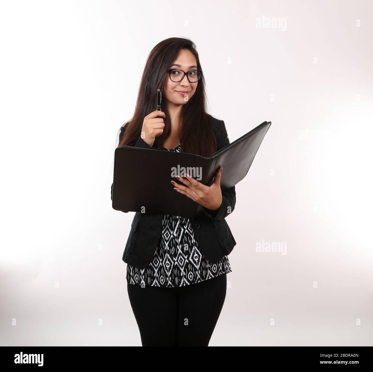 A pretty female executive assistant points pen up as she holds her ...