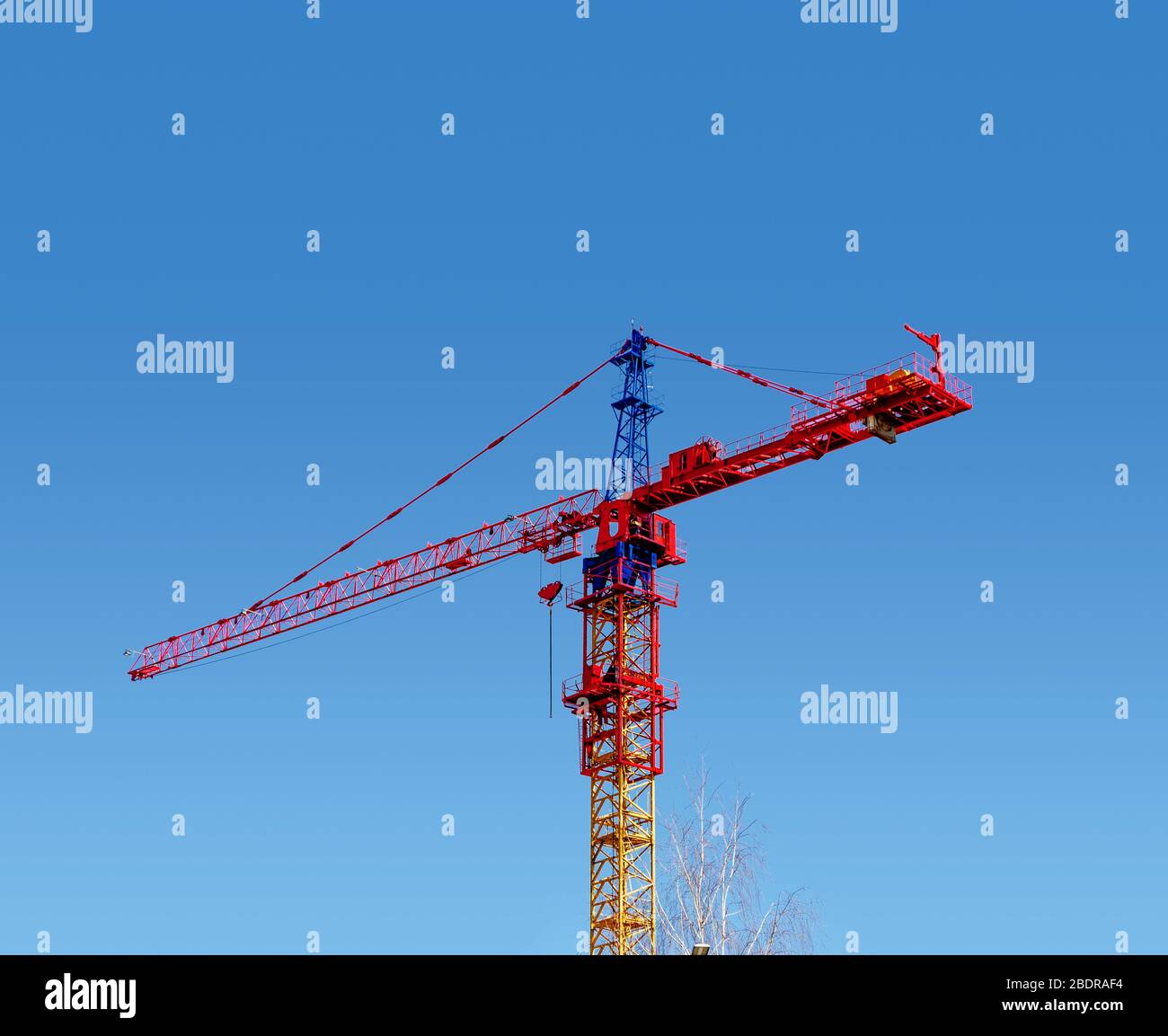 Tower crane red color on a blue sky background. Construction, industry ...