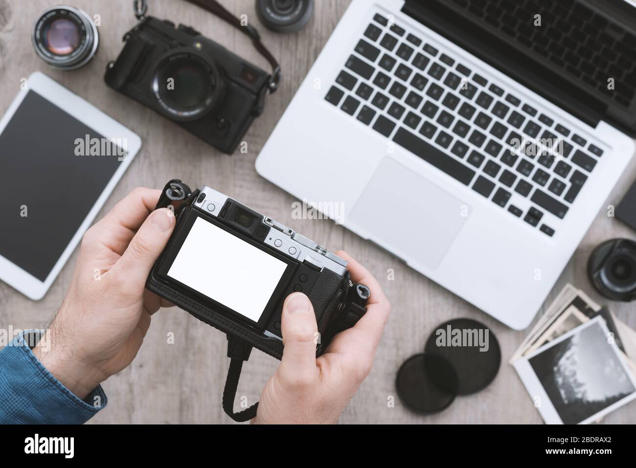 Professional photographic equipment, tablet and laptop on a desktop, a ...