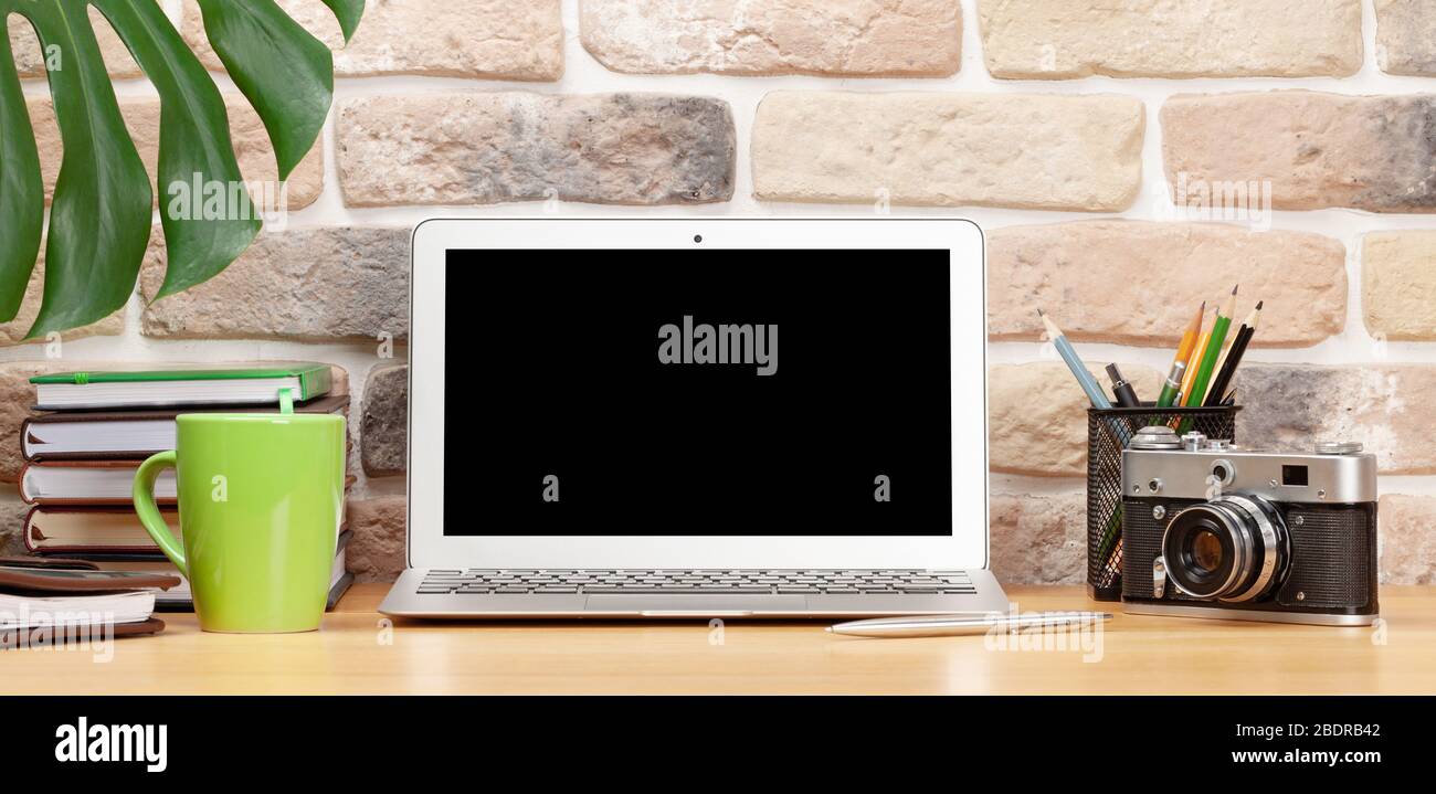 Stylish home studio workspace with laptop computer, camera and supplies ...