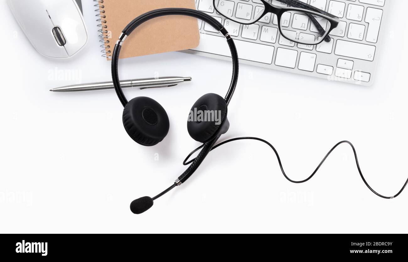 White office desk with computer, headset and supplies. Tabletop. Remote ...