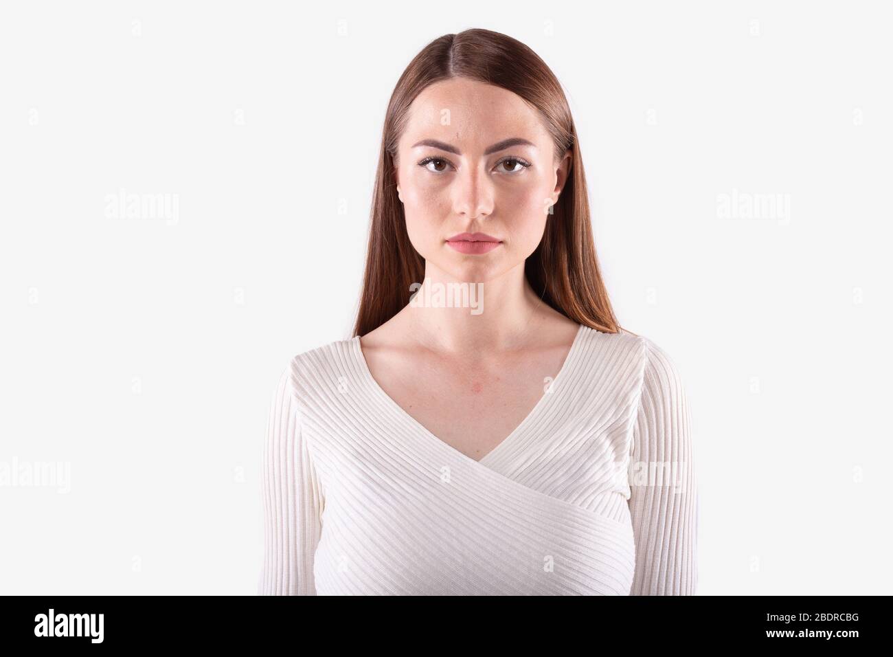 Attractive woman looks seriously at camera. Isolated on white ...