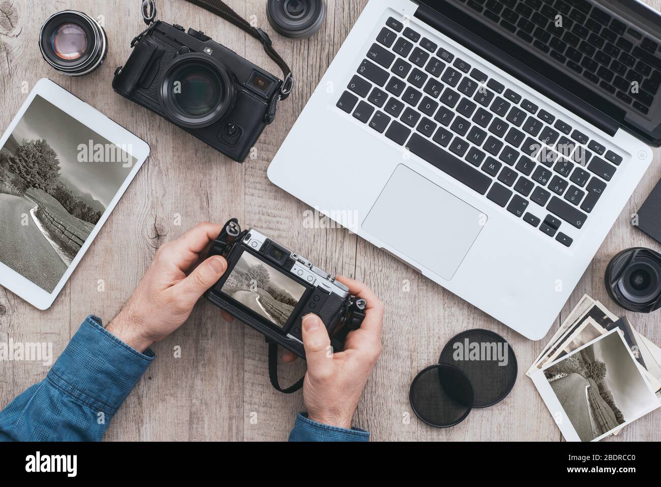 Professional photographic equipment, tablet and laptop on a desktop, a ...