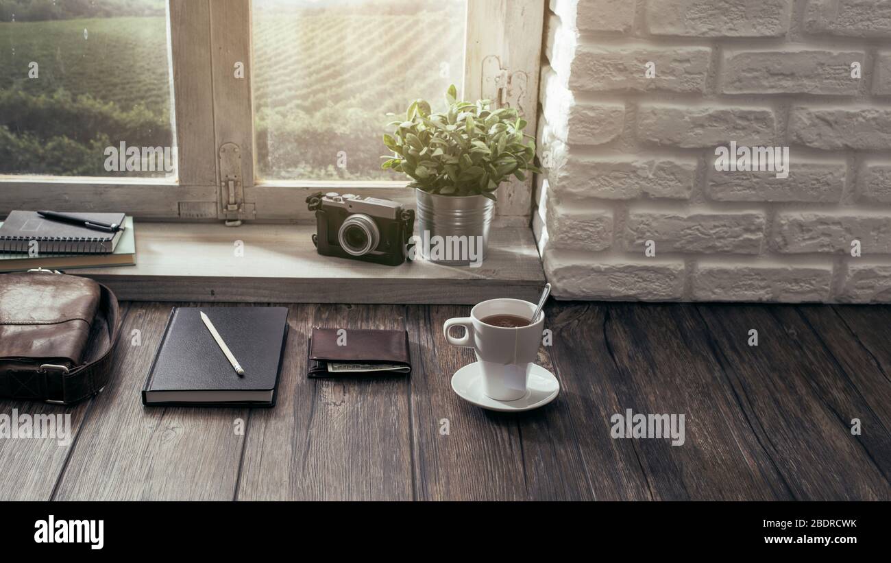 Hipster desk at home in front of a window with a cup of tea, a notebook ...