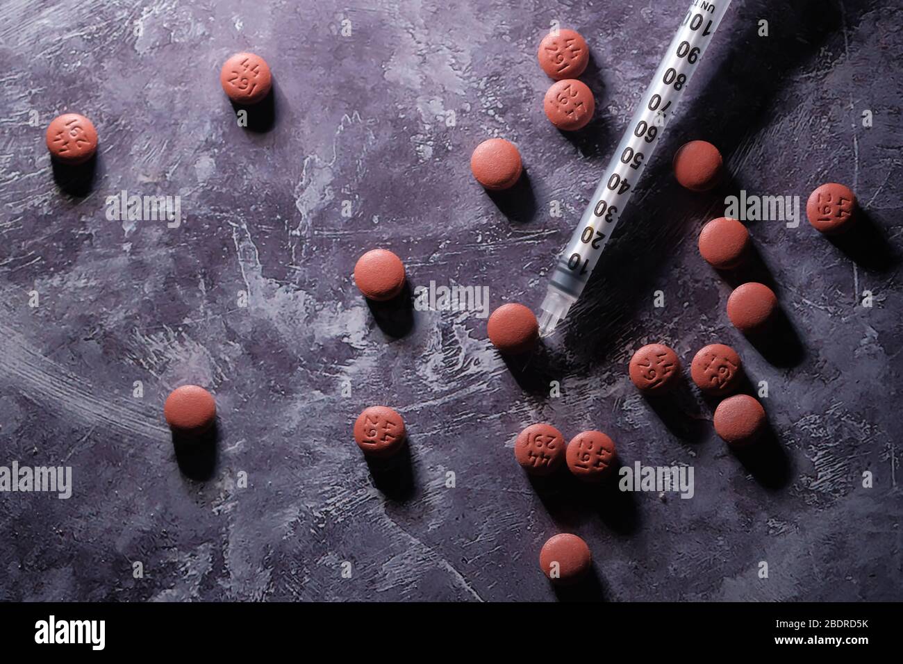 Assorted medical drugs and syringe on table Stock Photo - Alamy