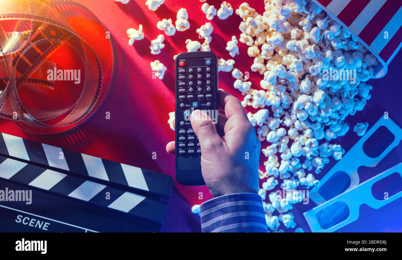 Hand holding a television remote control, popcorn, filmstrip, 3D ...
