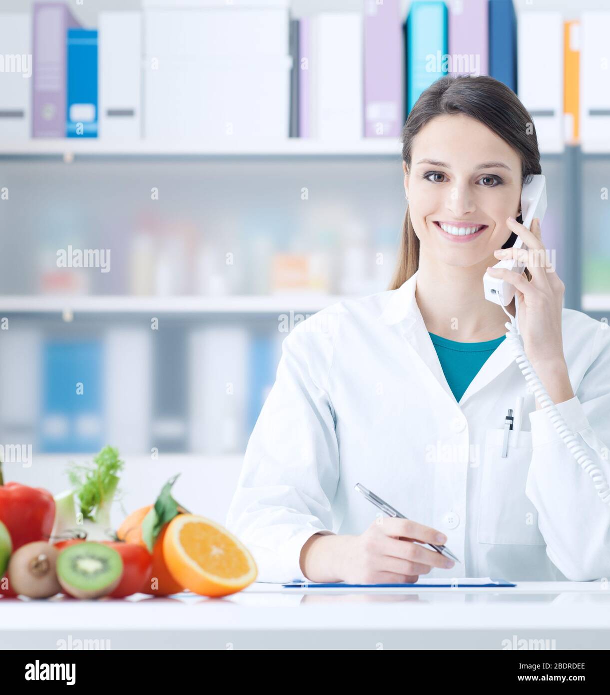Smiling nutritionist having a phone call and scheduling appointments ...