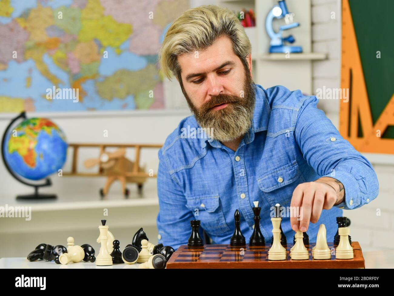 moving pieces on chess board. man hold chess piece. Concentrated man ...