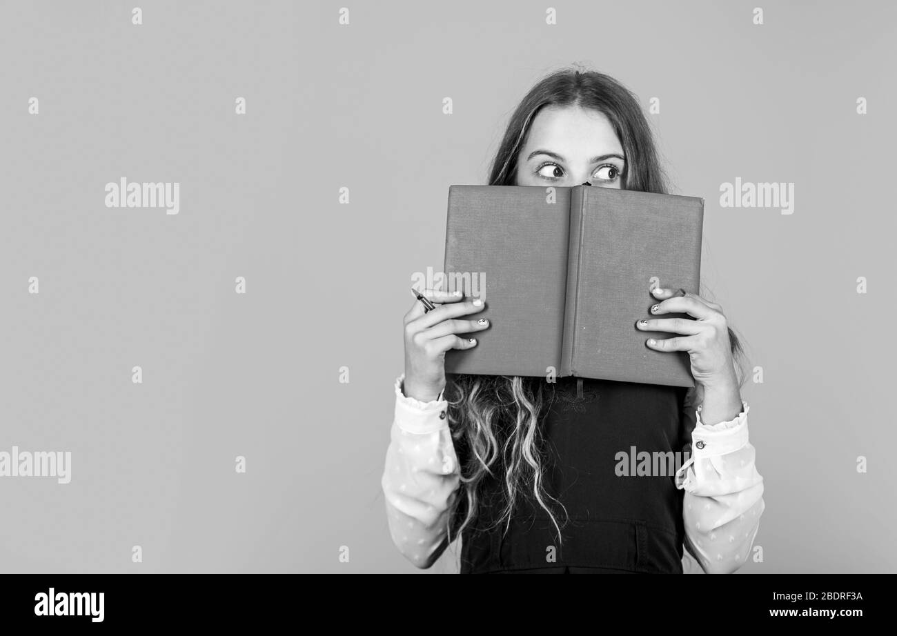 Looking for relevant information. Little girl cover face with book ...