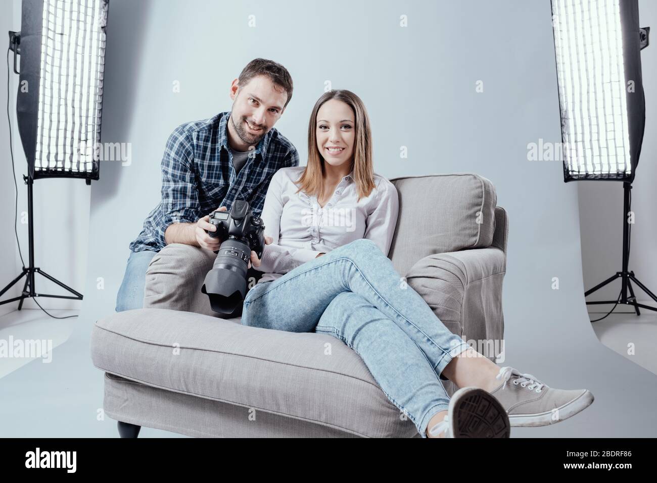 Professional photographer posing in the studio with a beautiful young ...