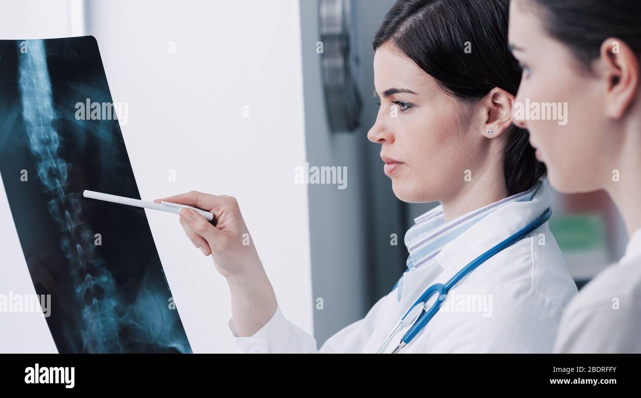 Professional doctor examining a patient's x-ray and pointing, medical ...