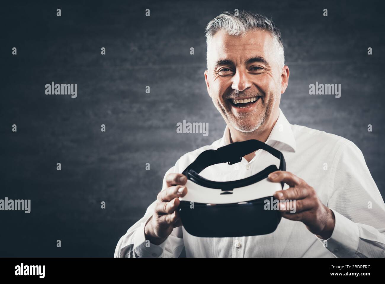 Confident smiling man wearing a VR headset, virtual reality and ...