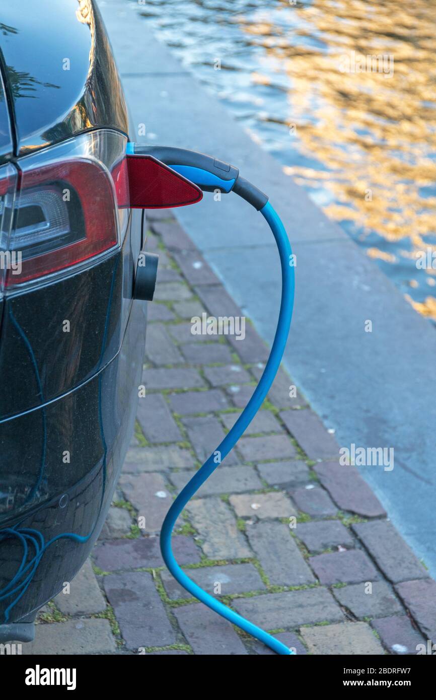 Charging Plug in Electric Vehicle Near Canal Water Stock Photo - Alamy