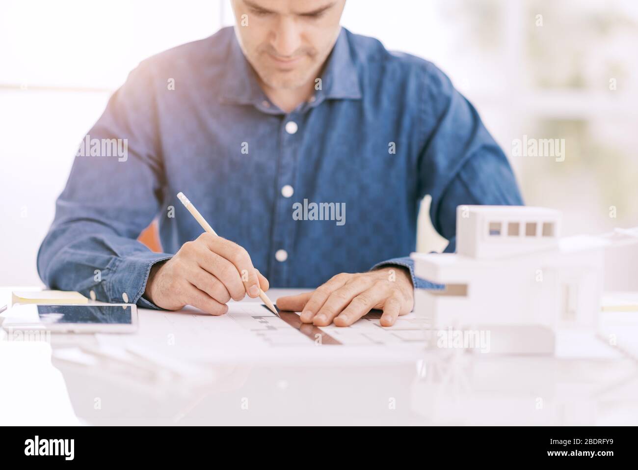 Professional architect working at office desk, he is drawing with a ...