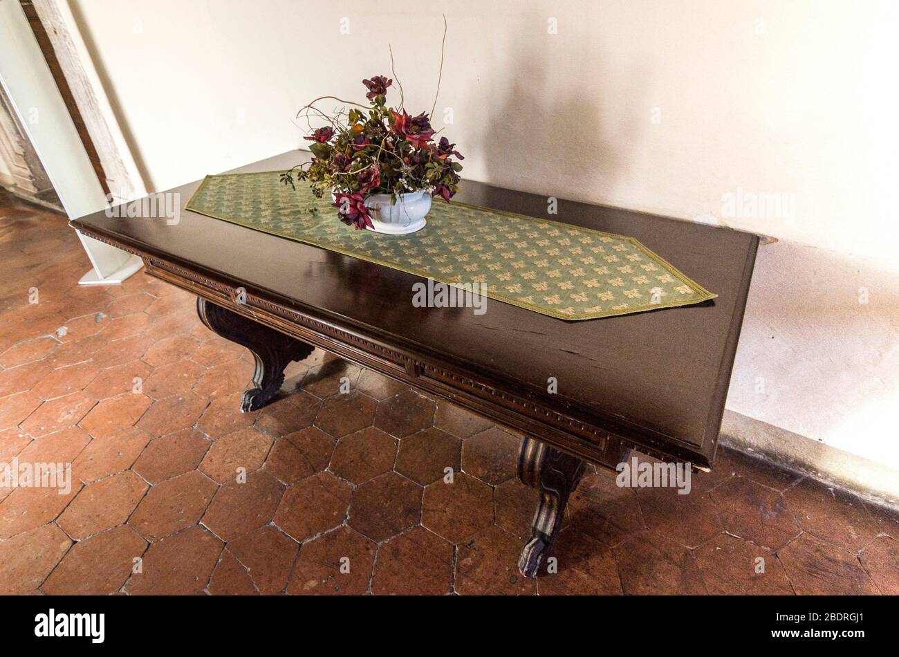 Ancient wooden table with centerpiece and flowers Stock Photo - Alamy