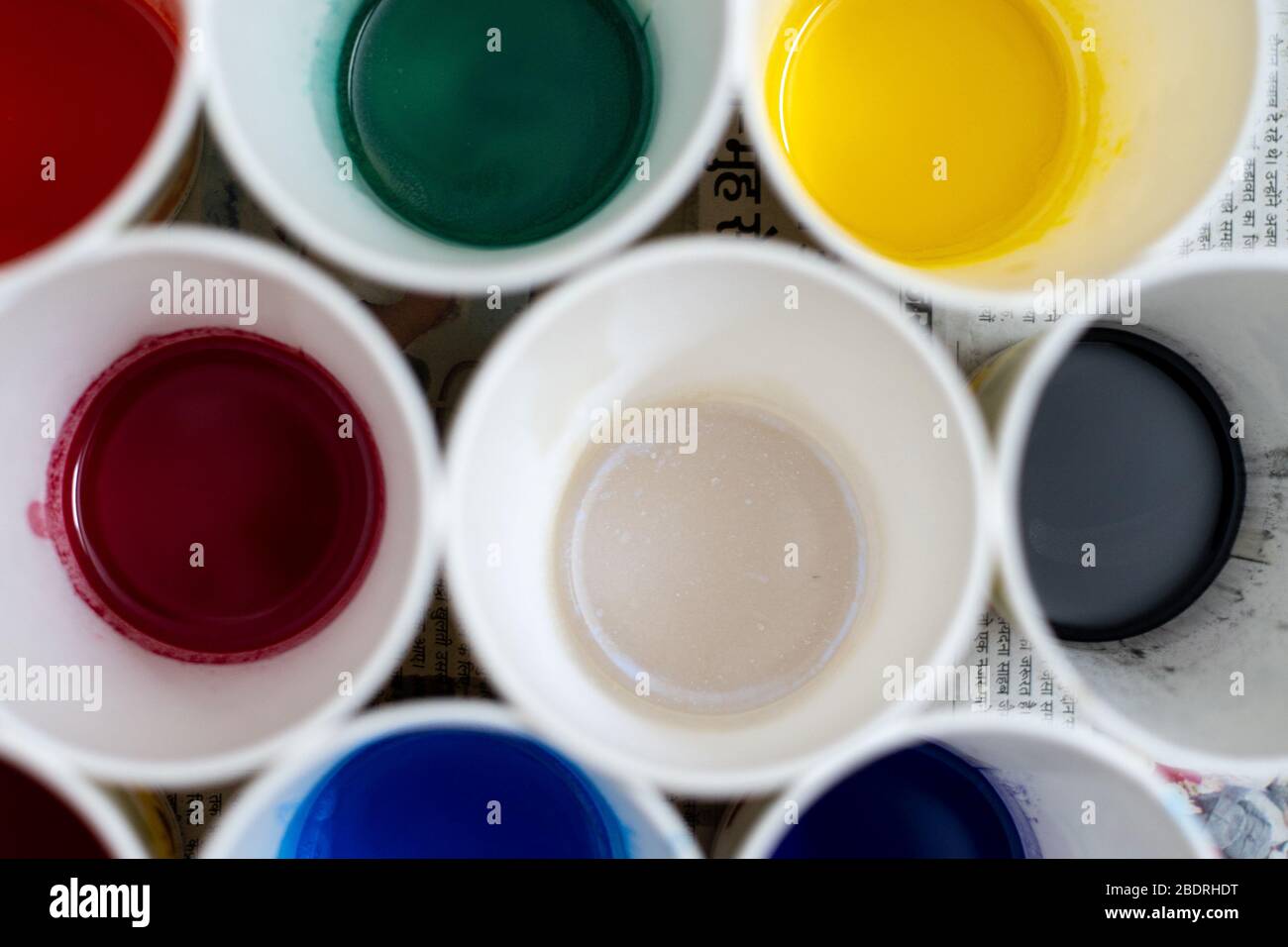 Overhead shot of colorful liquid in paper cups showing soap, food color ...