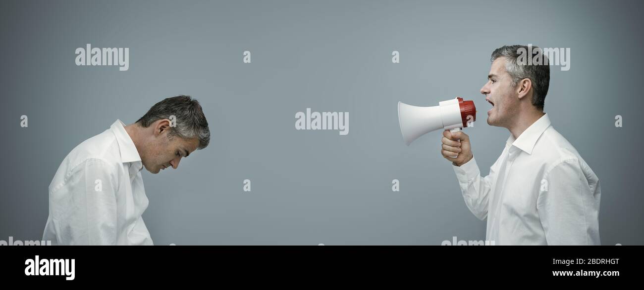 Confident man shouting with a megaphone and spreading his message ...