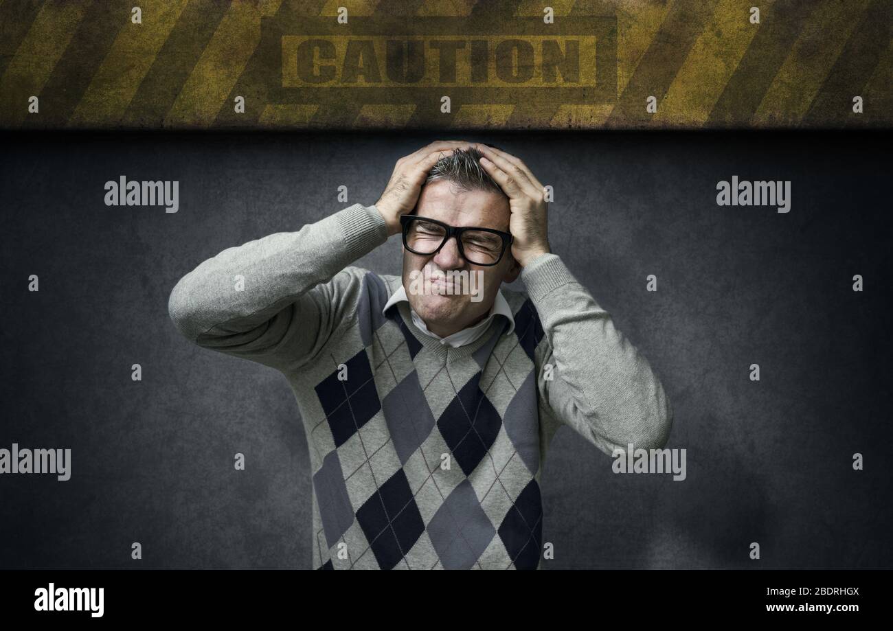 Stressed nerd guy having and headache and holding his head, pressure ...