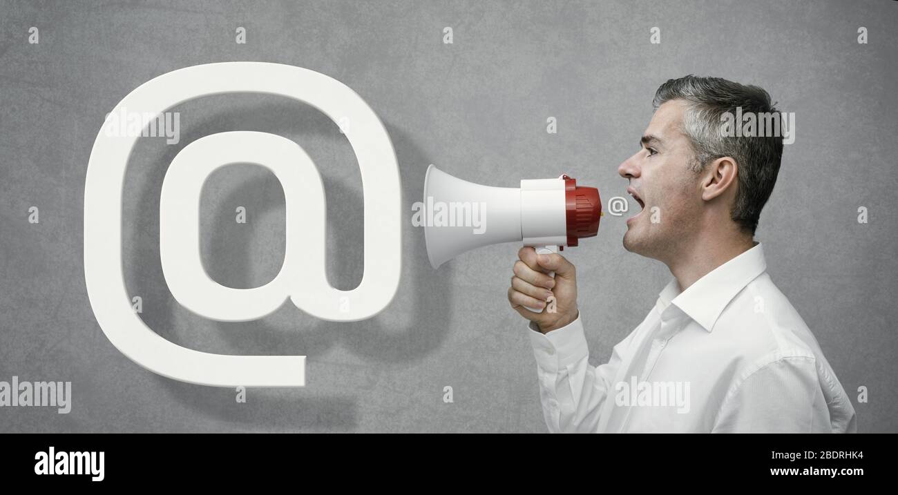 Confident man shouting with a megaphone and spreading his message ...