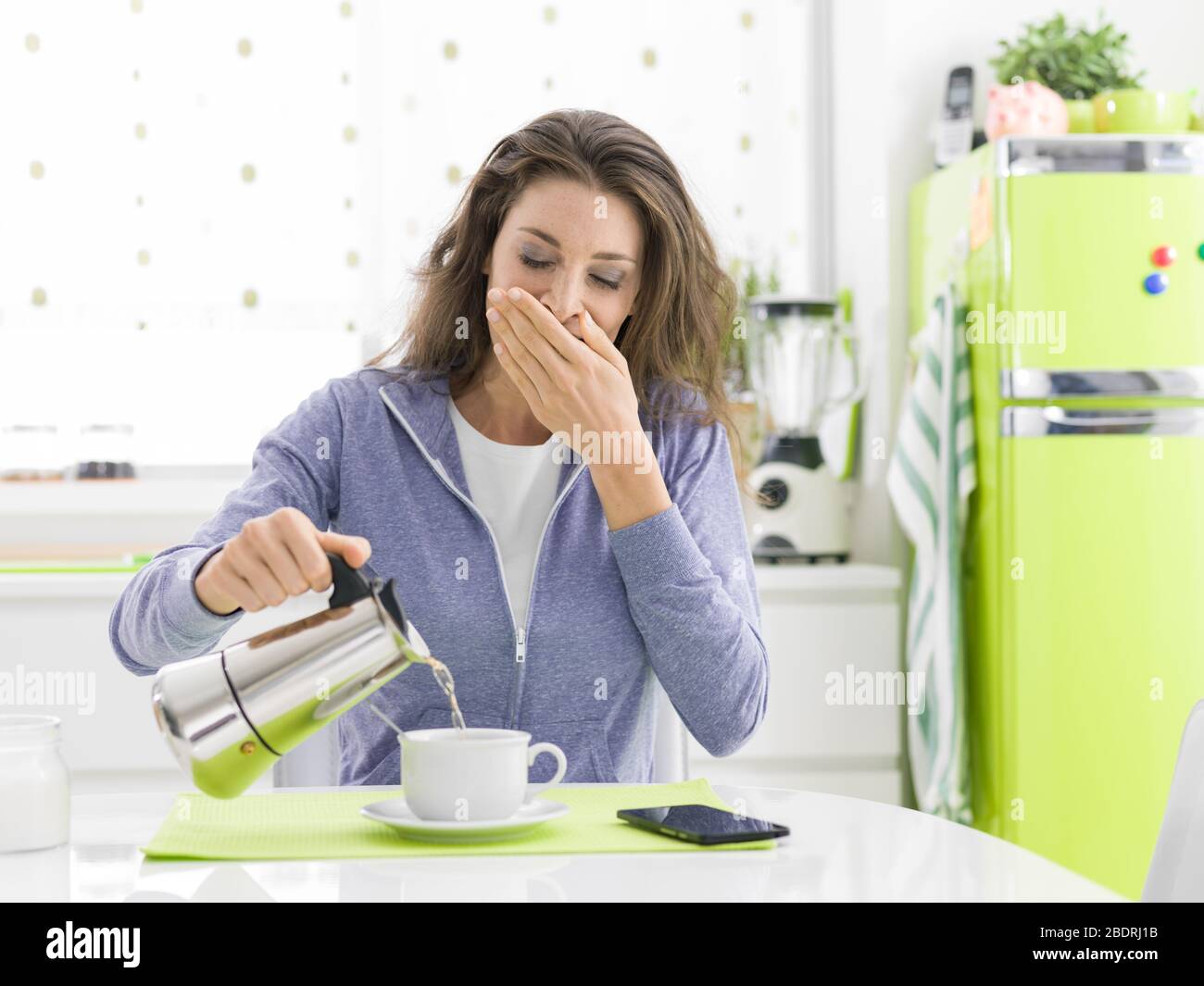 Tired lazy woman having breakfast at home in the kitchen, she is ...