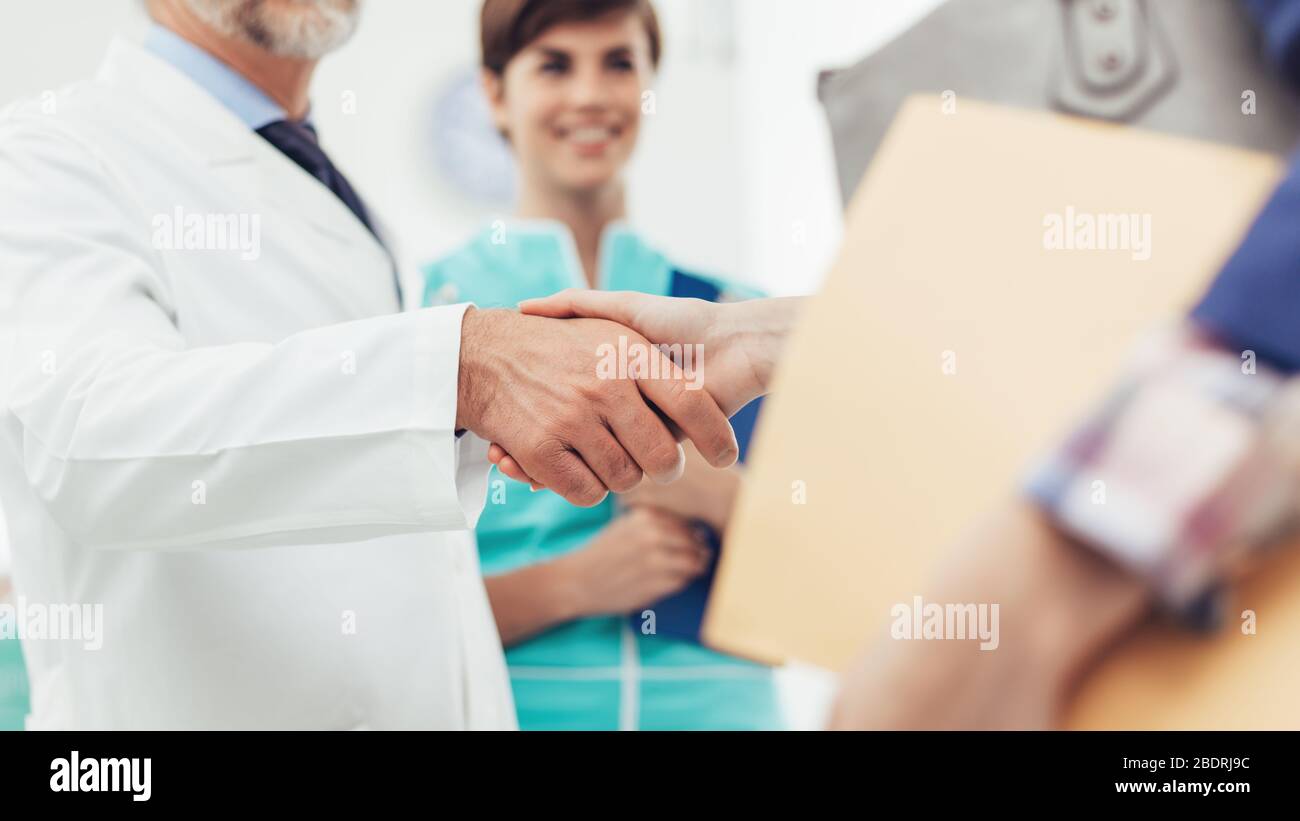 Medical staff welcoming a patient at the clinic: the doctor is giving ...