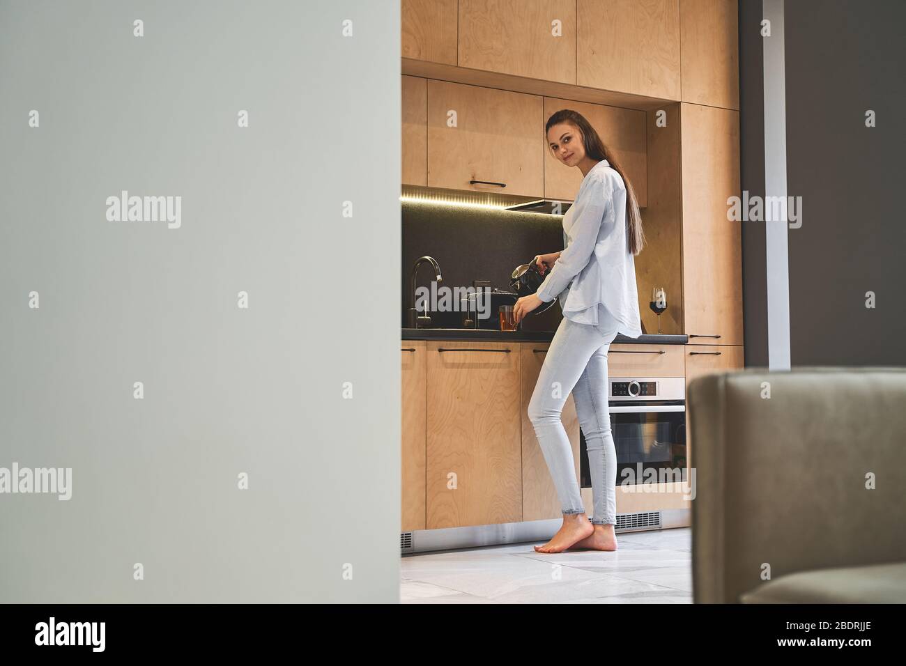 Lovely barefoot girl standing in the kitchen Stock Photo - Alamy