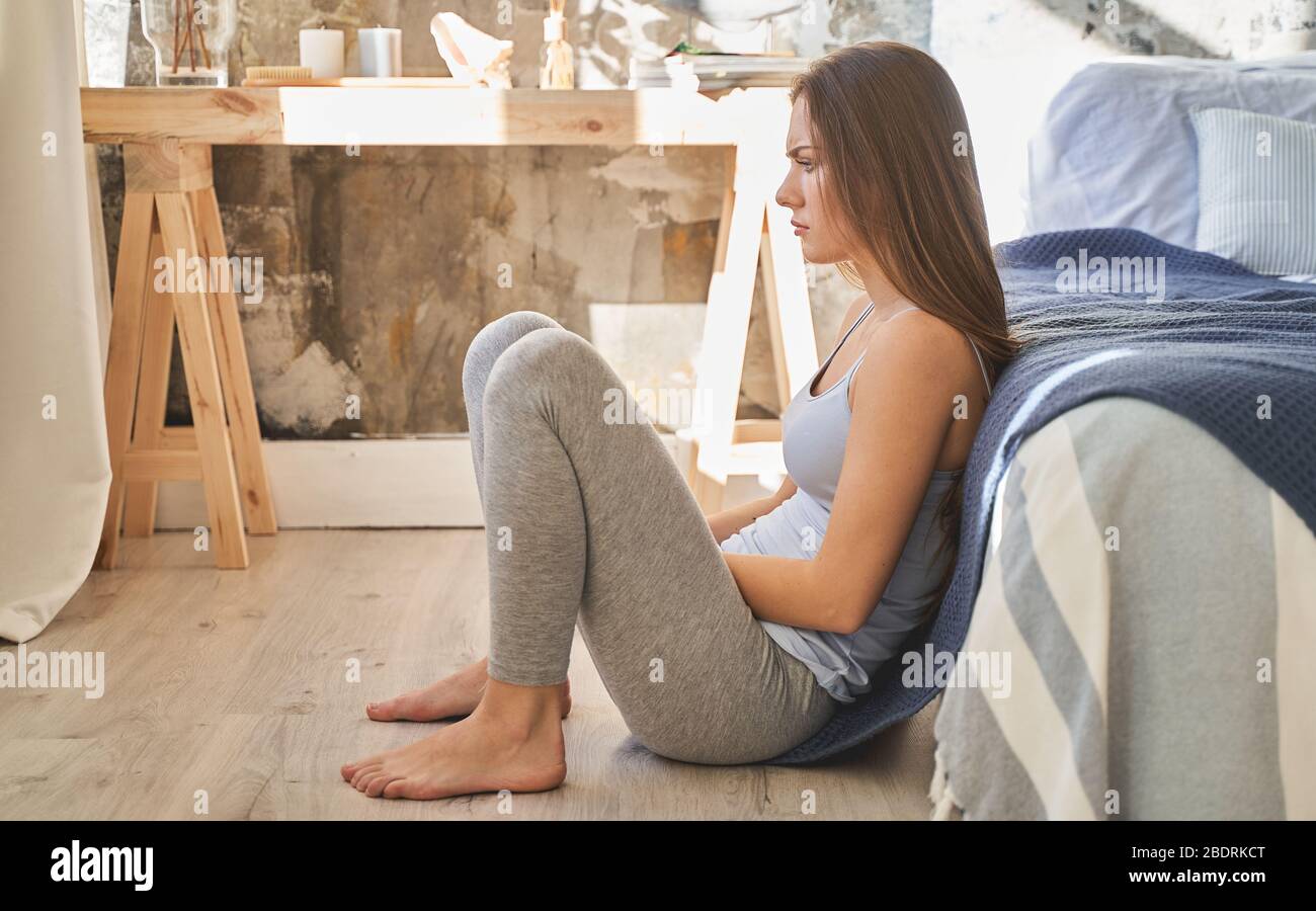 Serious female person sitting in semi position Stock Photo - Alamy