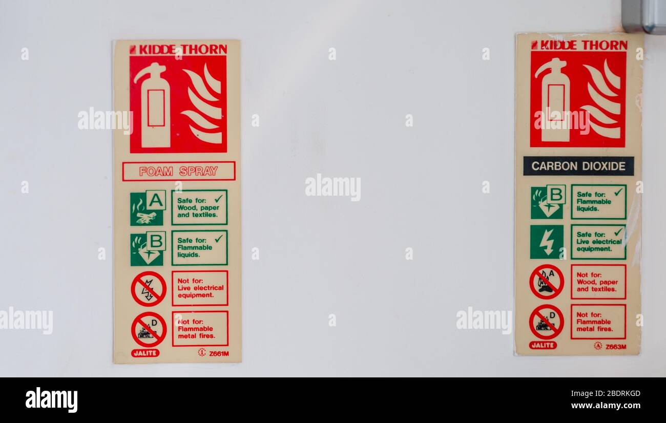 Fire extinguisher sign on red background in white wall Stock Photo - Alamy
