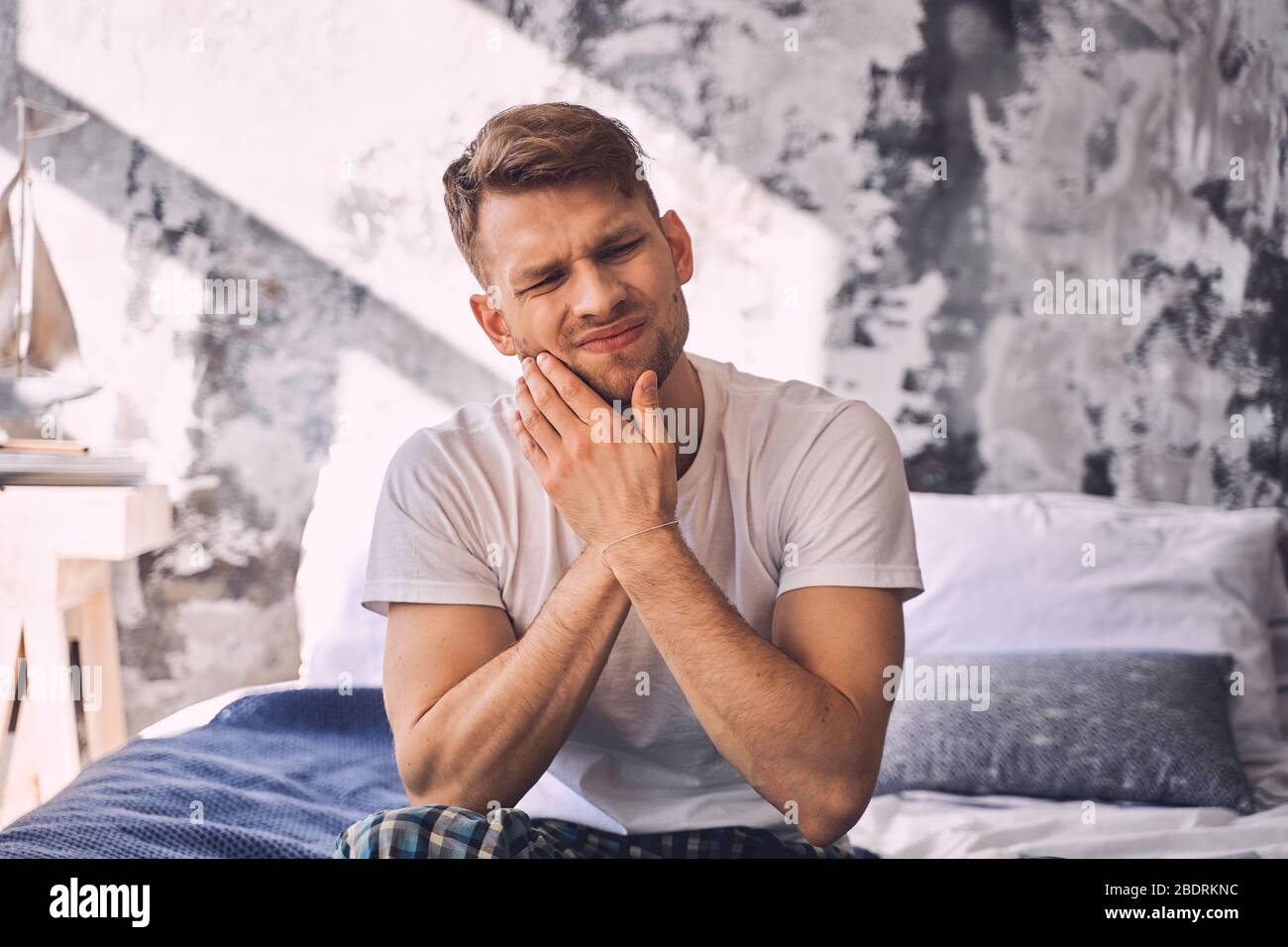 Close up of upset man that touching his cheek Stock Photo - Alamy