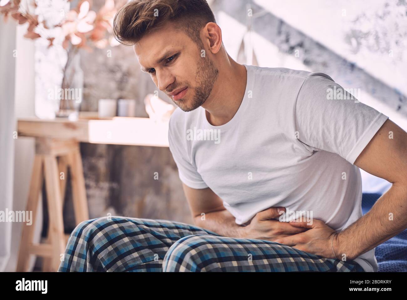Young male person making face from pain Stock Photo - Alamy