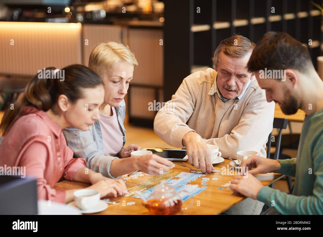 Group of people playing in board games together at the table and ...