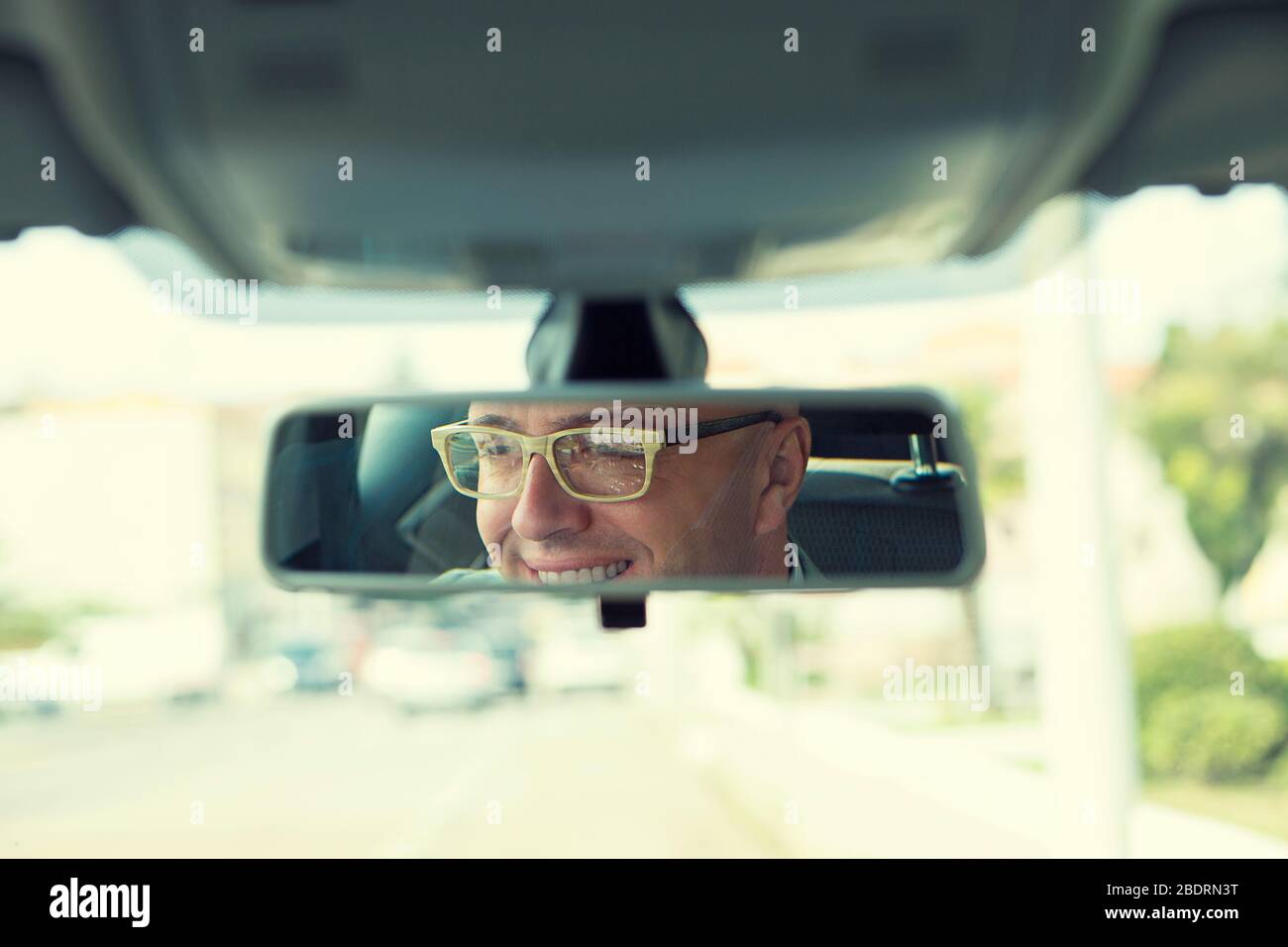 Happy with my car choice. Portrait young man driver reflection in car ...