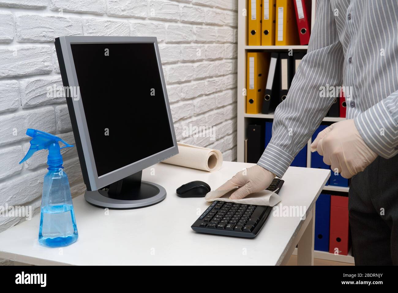 concept of cleaning or disinfecting the office - a businessman cleans ...