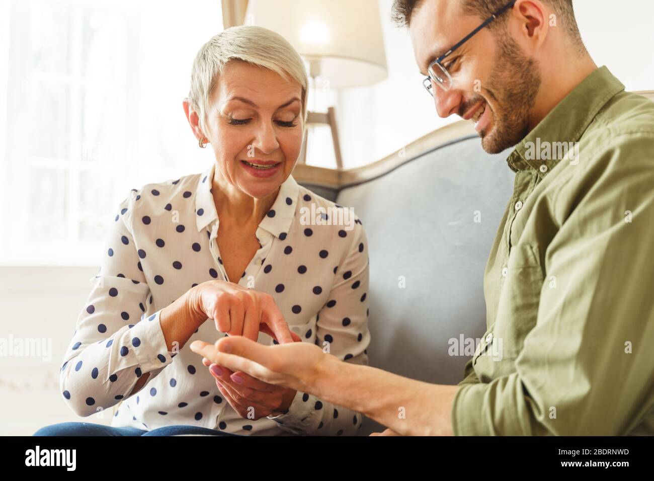 Female soothsayer looking at her clients palm Stock Photo - Alamy