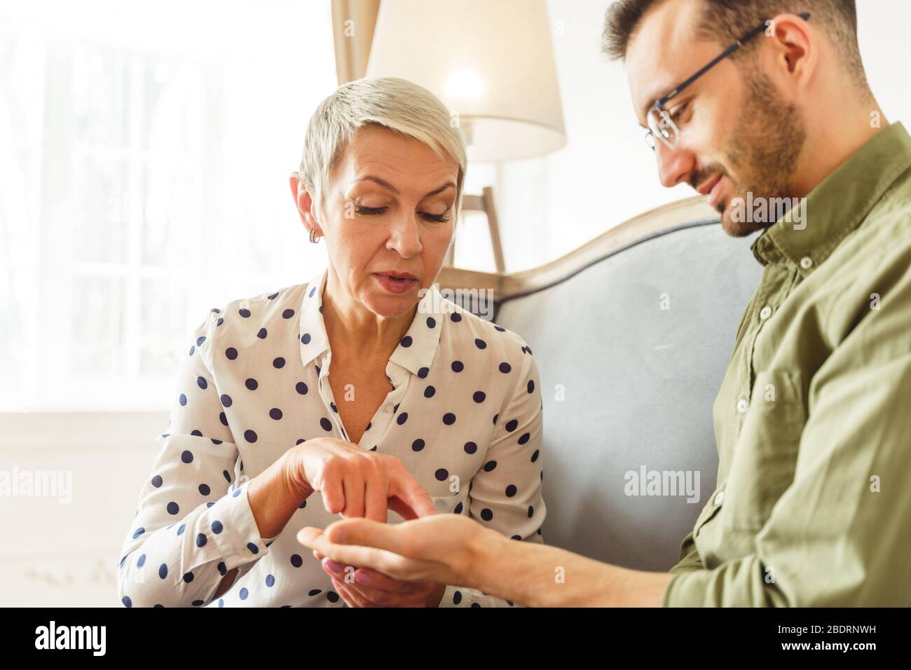 Focused client listening to a senior fortune-teller Stock Photo - Alamy