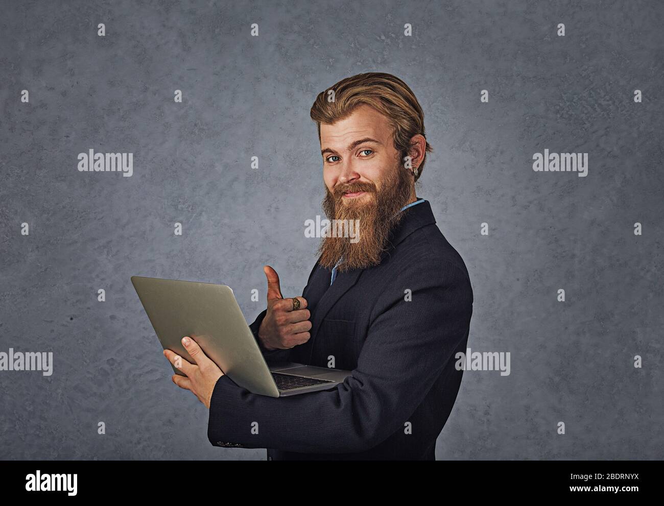 Portrait handsome smiling businessman working with laptop giving thumbs ...