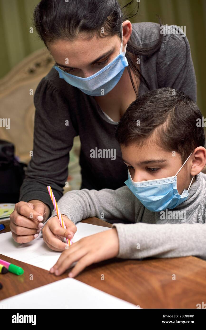 Distance education. Mother helps pre-school kid to do lessons ...