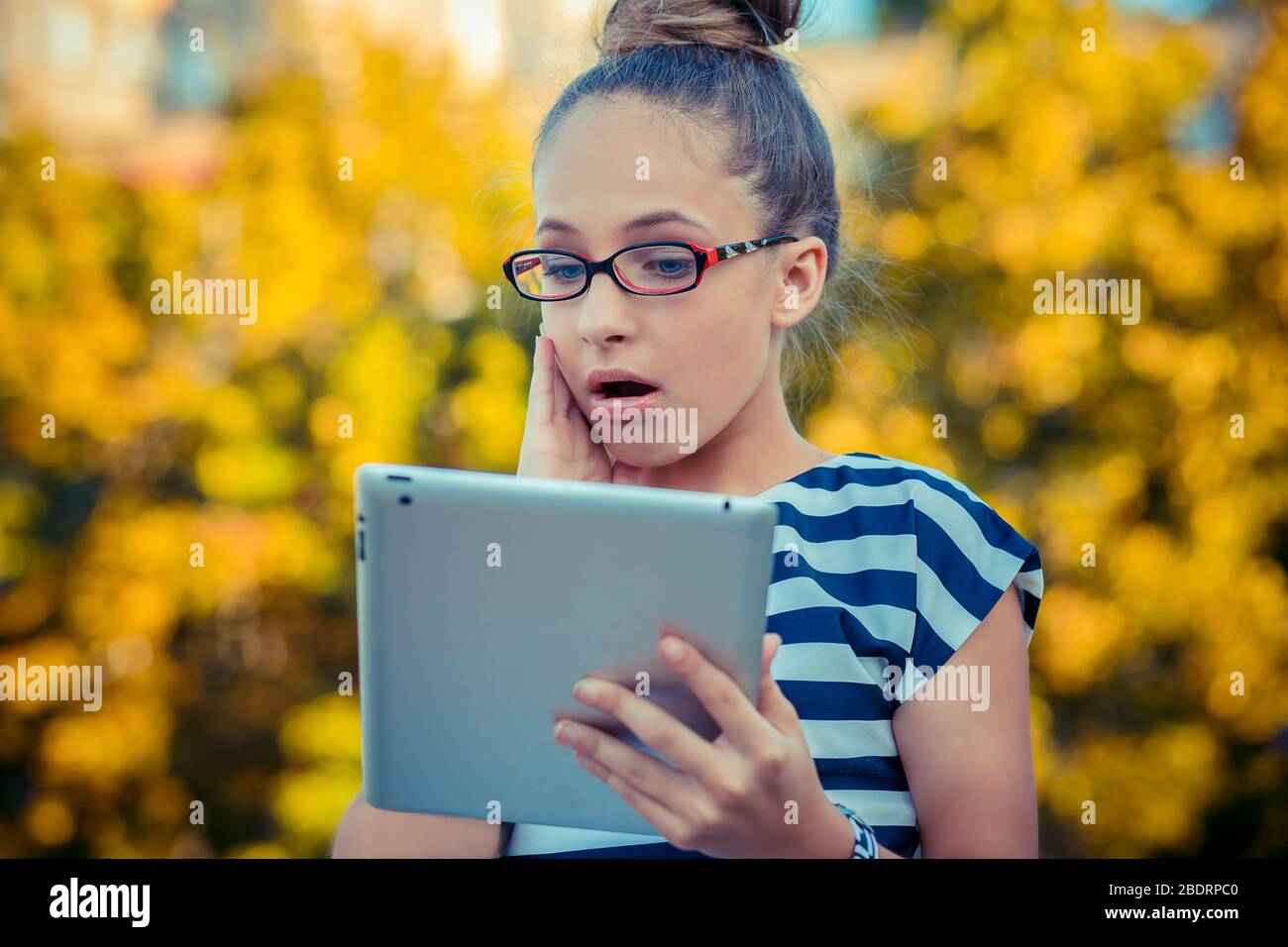 Closeup portrait anxious young girl looking at phone seeing bad news or ...