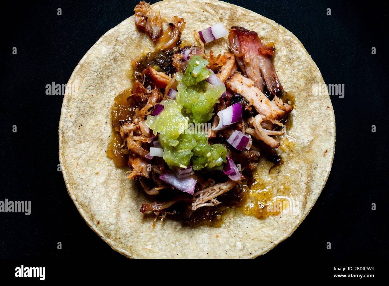 Carnitas tacos with red onion and raw salsa verde. Mexican slow cooked ...
