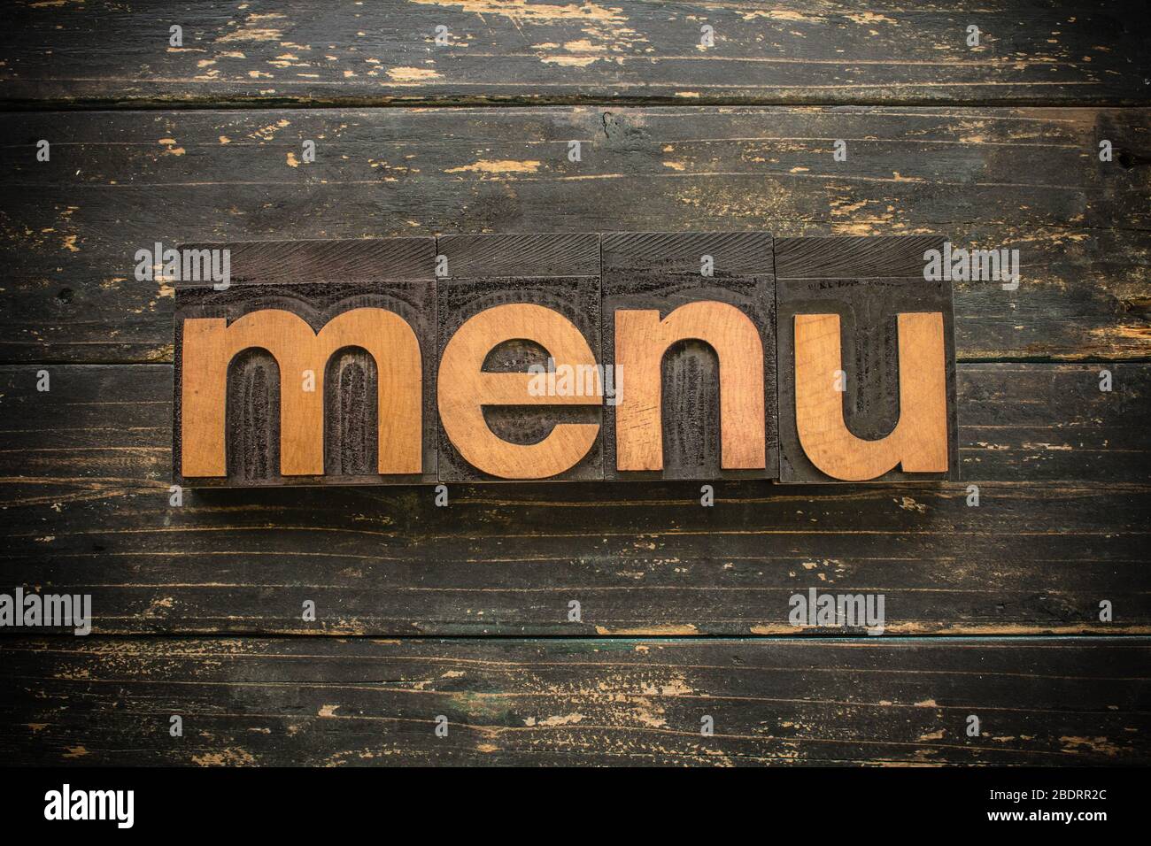 The word "MENU" written in vintage wood letterpress type on a vintage ...