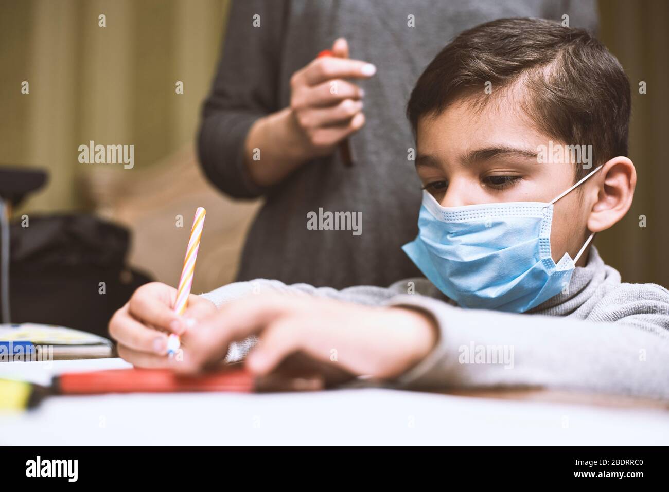 Distance education. Mother helps pre-school kid to do lessons ...