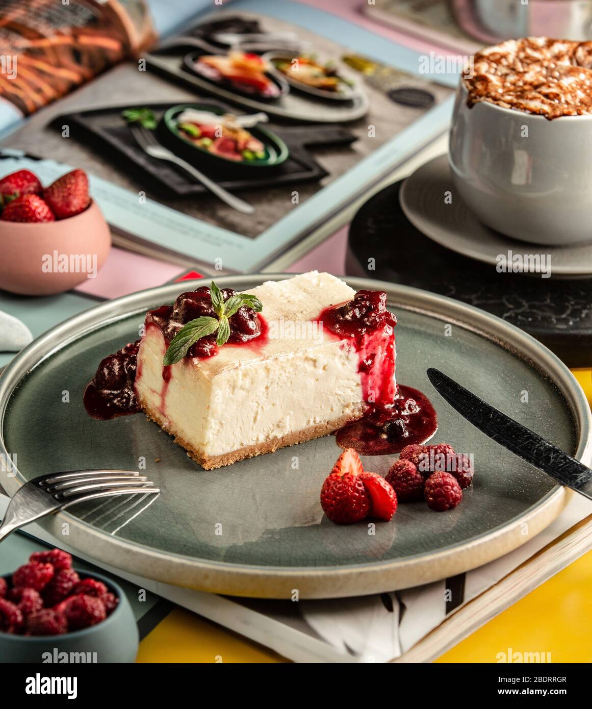 cheesecake slice garnished with berry jam and pieces Stock Photo - Alamy