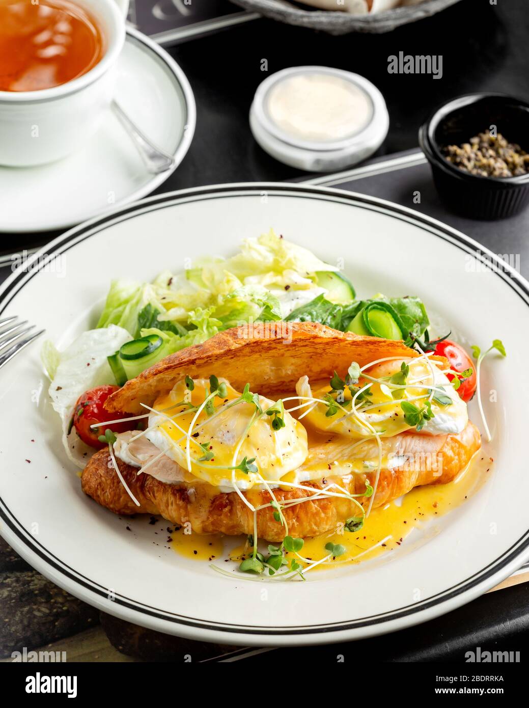 chicken sandwich with egg benedict in croissant served with green salad ...