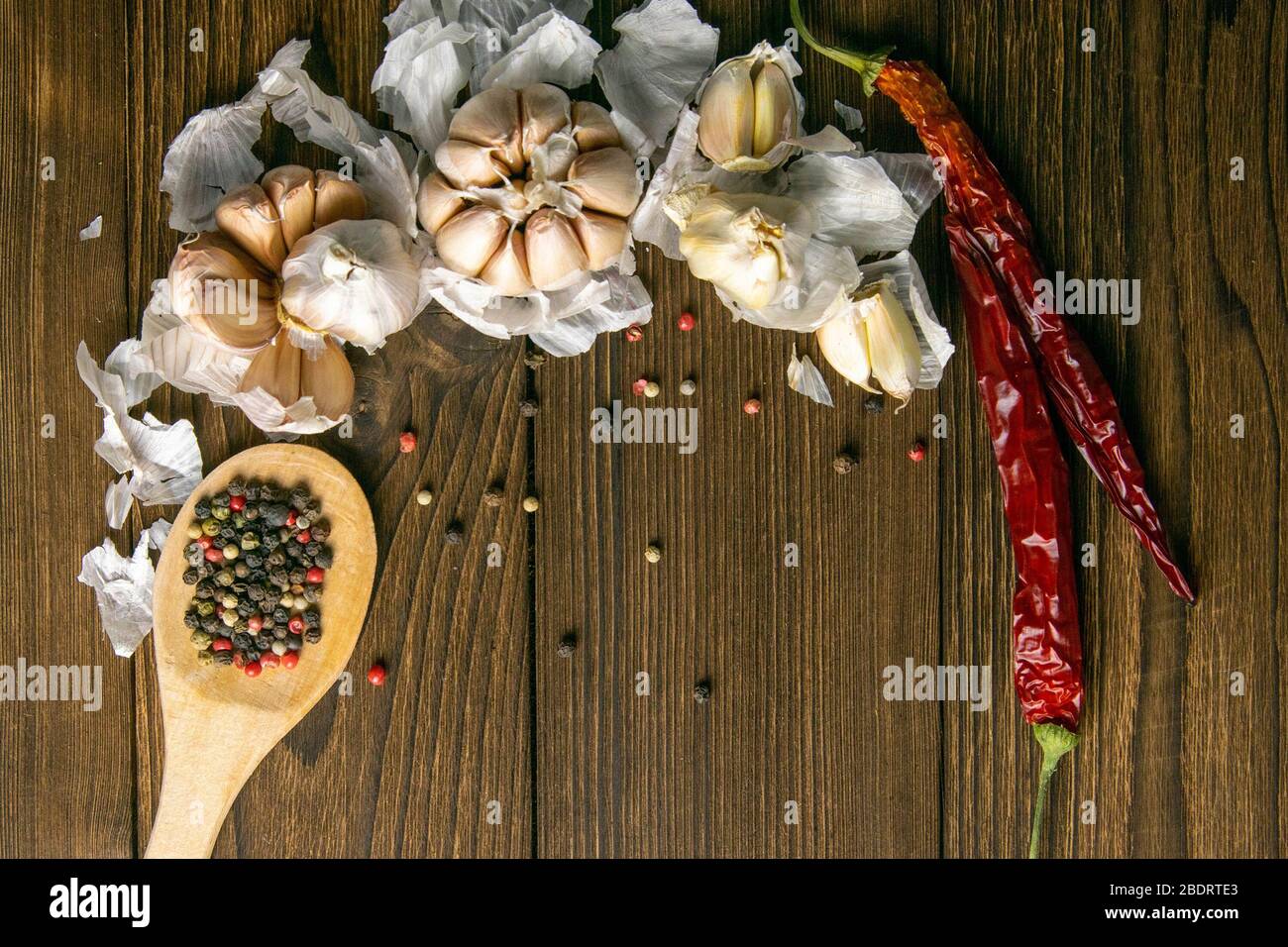 Red hot chili pepeprs, spices and garlic on dark wooden background, top ...